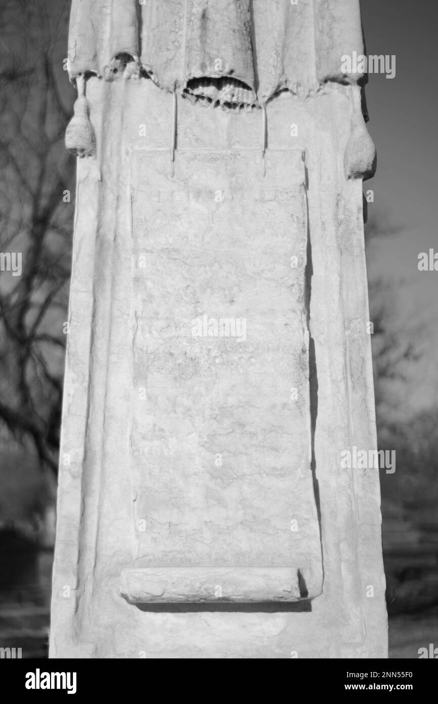 A worn and weathered old tombstone with a blank epitaph and room for ...