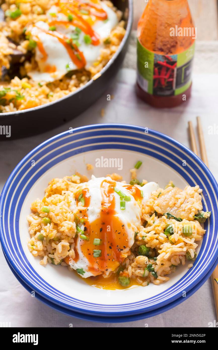Kimchi fried rice with peas, fried egg and sriracha sauce Stock Photo ...