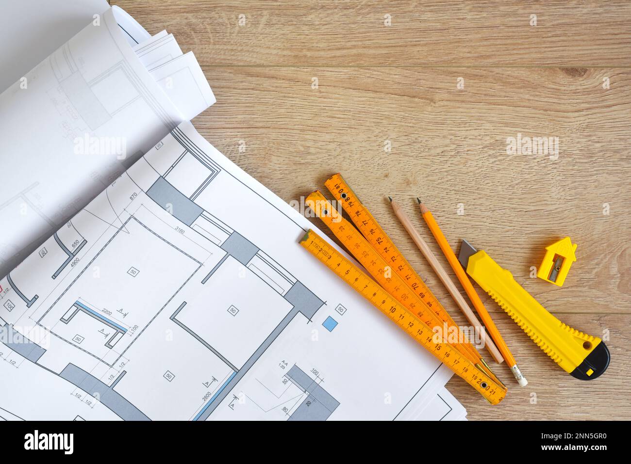 Architectural drawings and pencils, ruler, clerical knife on wooden ...