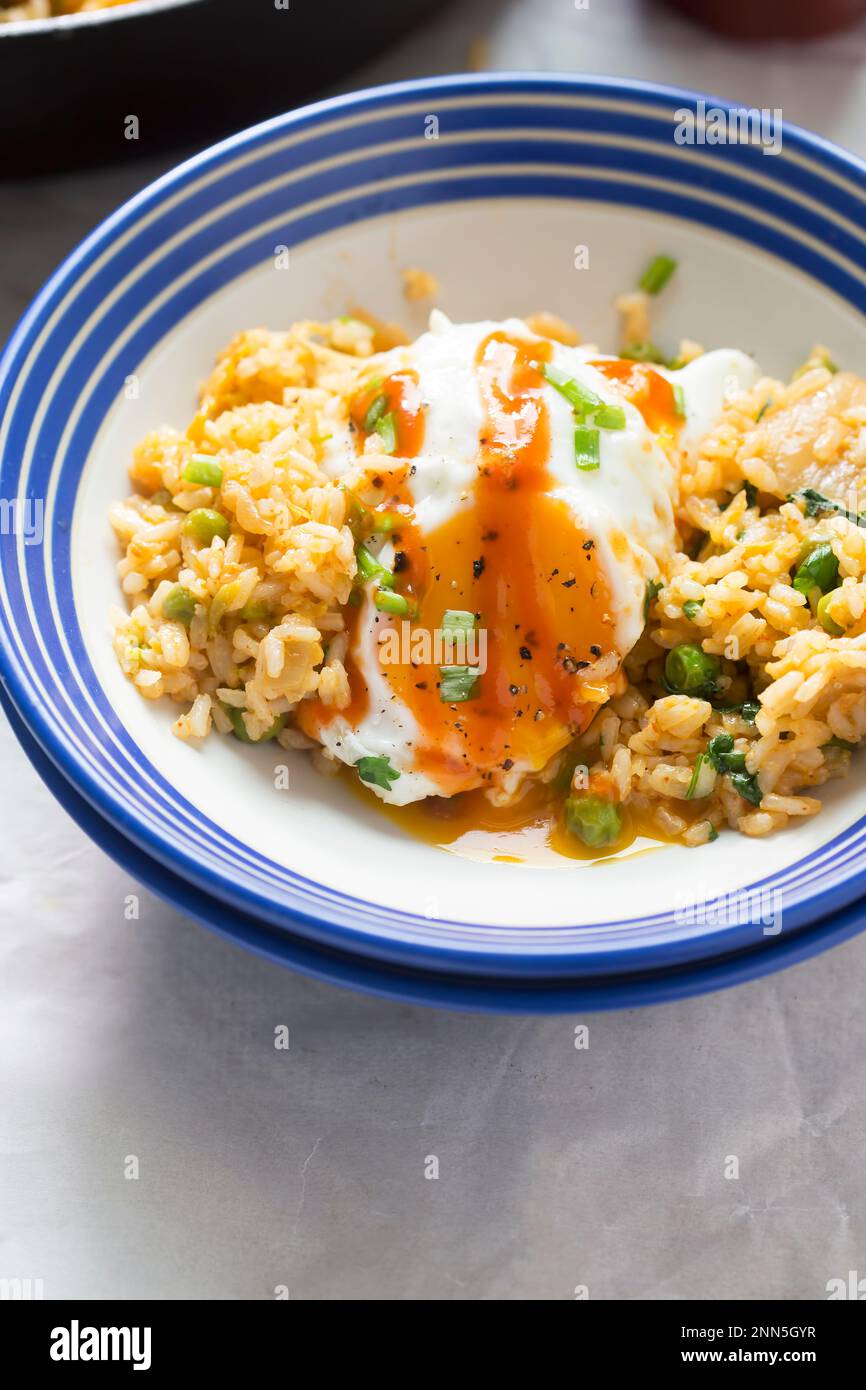 Kimchi fried rice with peas, fried egg and sriracha sauce Stock Photo ...