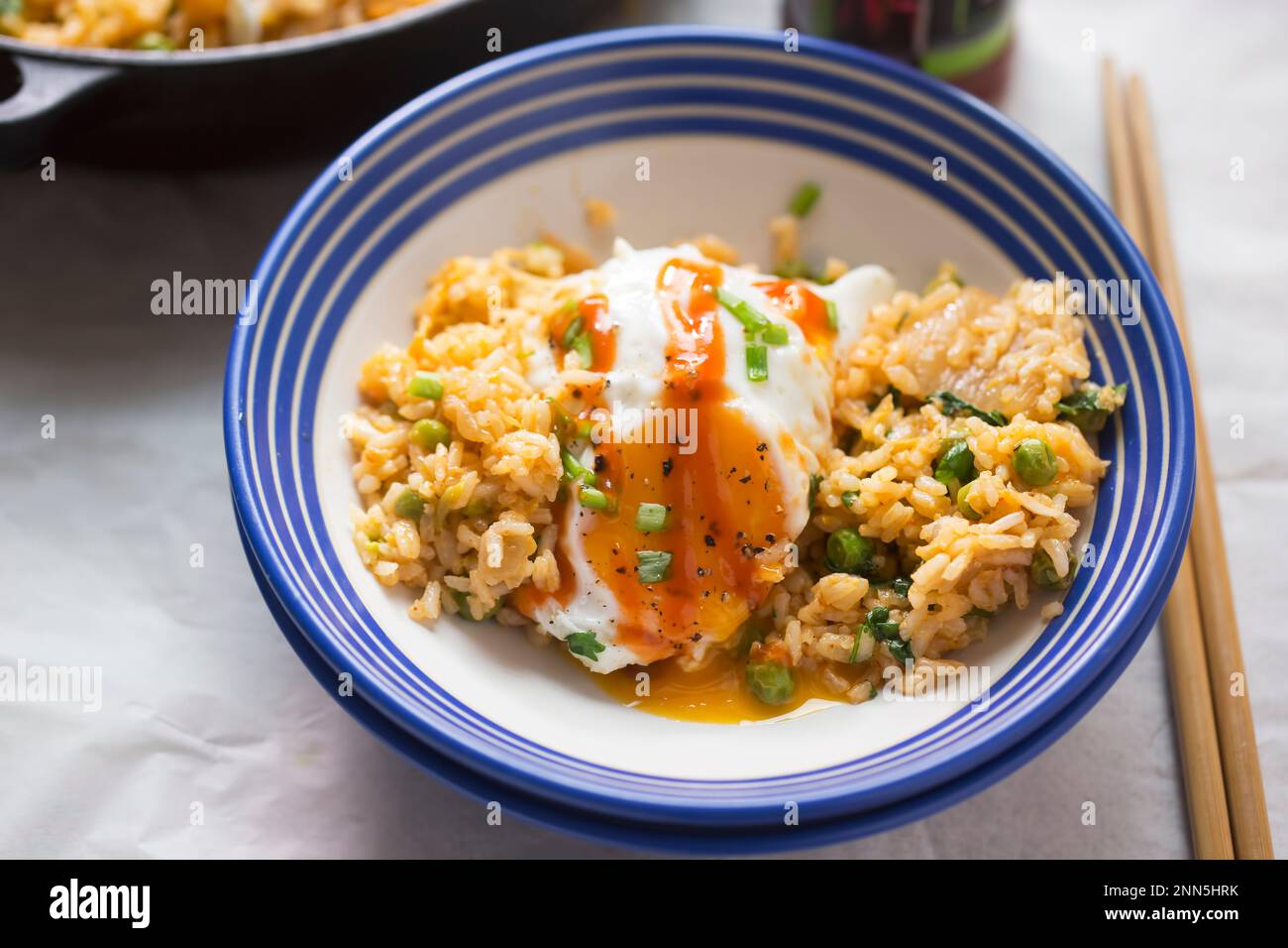 Kimchi fried rice with peas, fried egg and sriracha sauce Stock Photo ...
