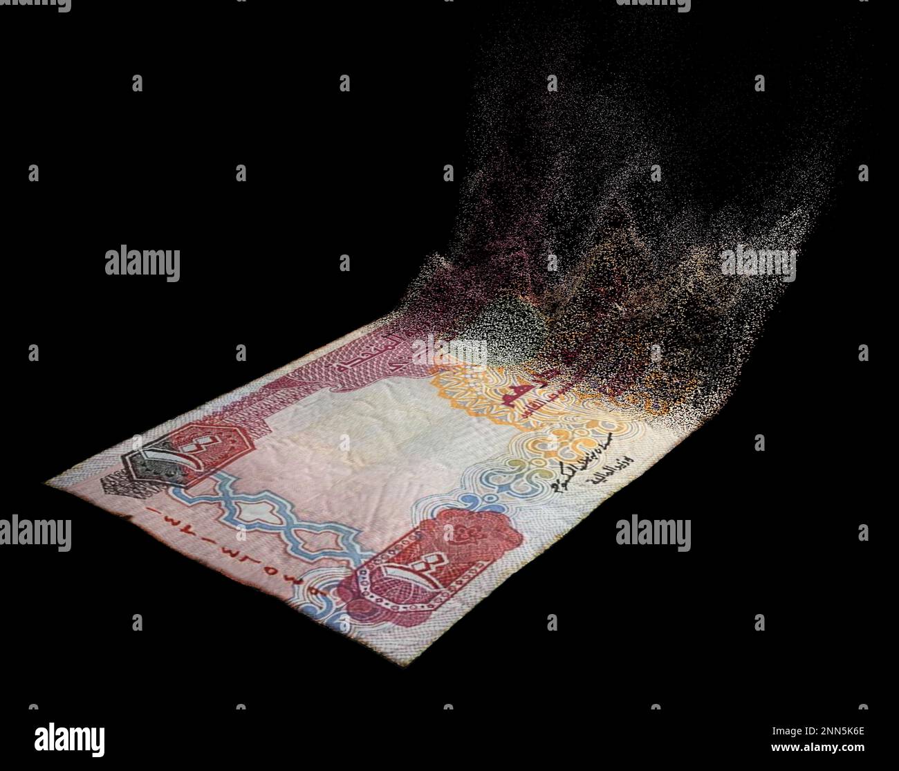 A concept image showing a half dissolved flat Dirham paper bank note on ...