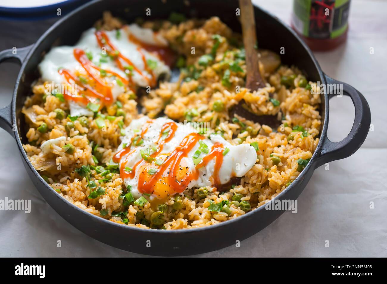 Kimchi fried rice with peas, fried egg and sriracha sauce Stock Photo ...