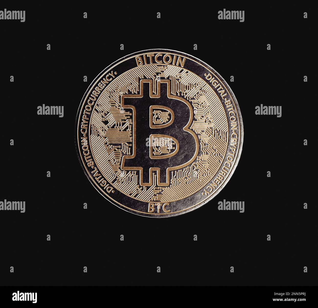 A dimly lit physical bitcoin cryptocurrency in bronze and silver coin ...