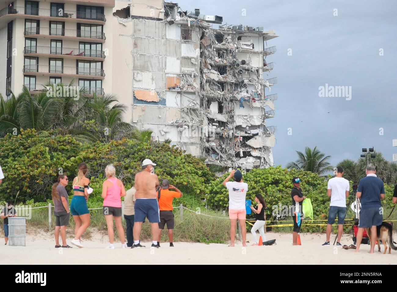 People look at the damage at the 12-story oceanfront Champlain Towers ...