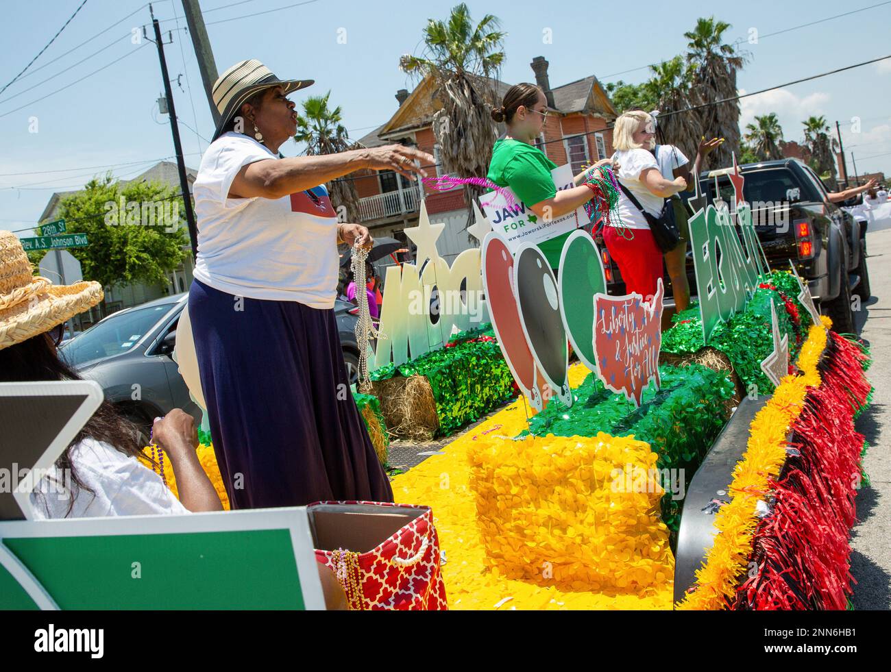 People on floats throw bead necklaces during the Juneteenth Parade on ...
