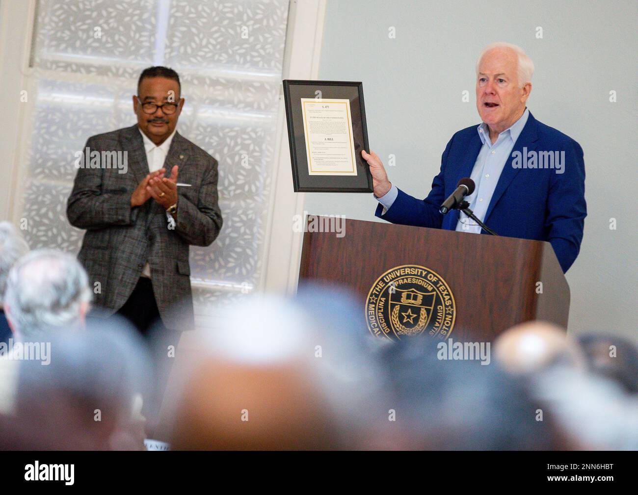 Senator John Cornyn, R-Texas, holds up bill S.475 which declared ...