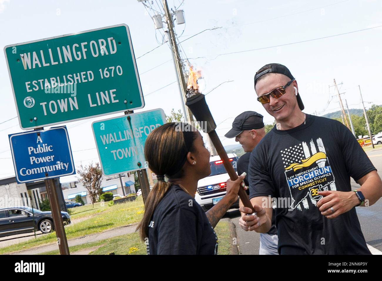 Wallingford police Ofc. Nick Judkins hands off the torch to Meriden ...
