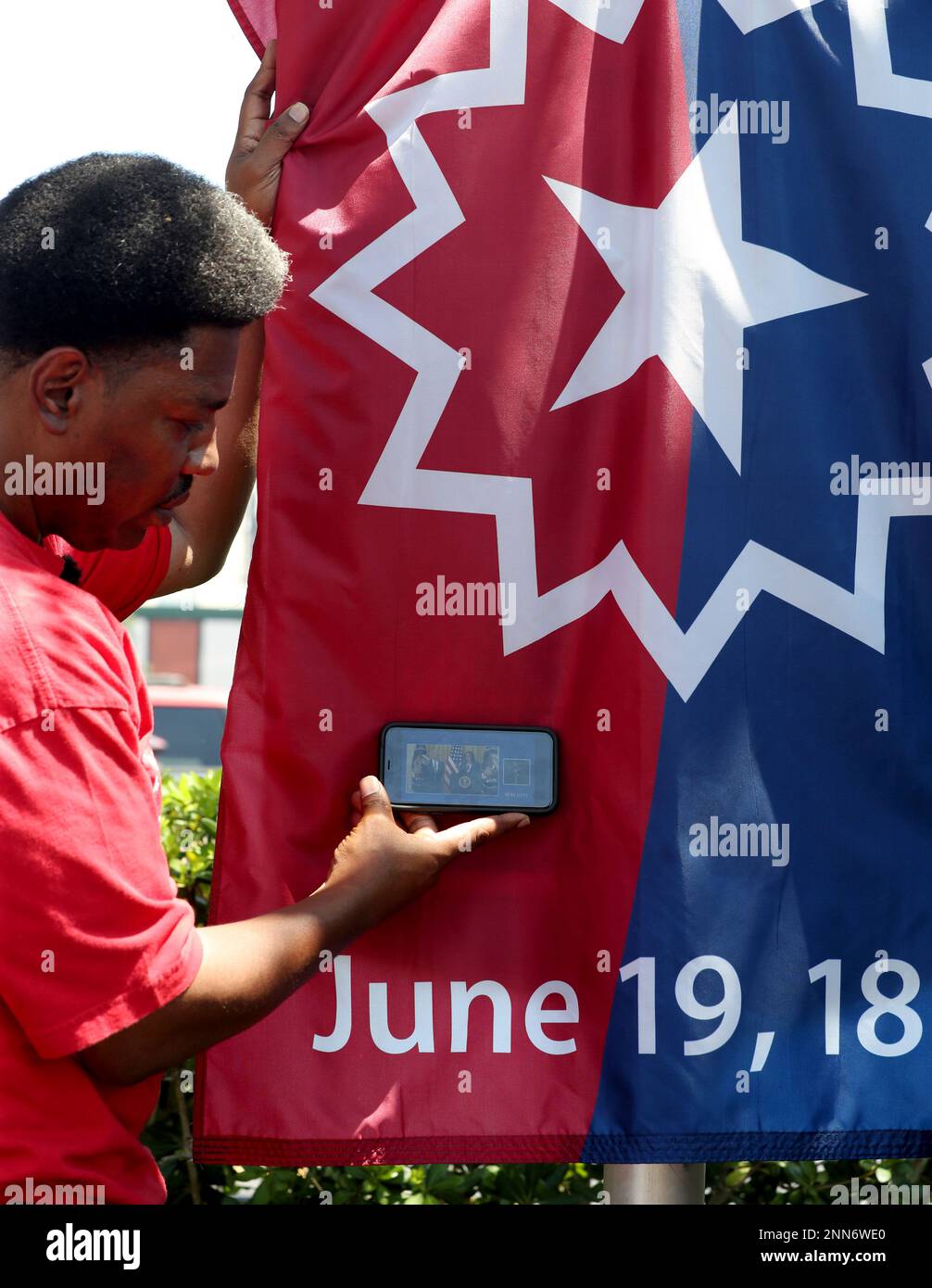 Sam Collins III watches Vice President Kamala Harris on his cell phone ...