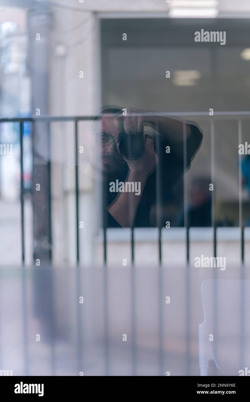 A photographer is taking picture of himself on the window Stock Photo ...
