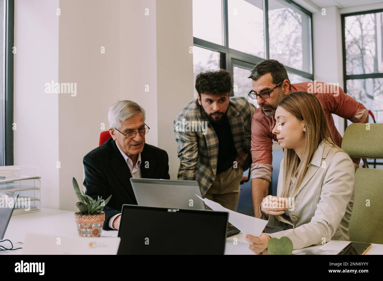 Four colleagues working together at the office. They are exhausted and ...