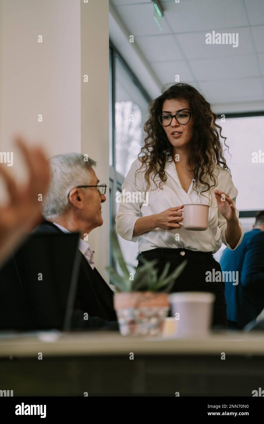 A kind senior business person listening carefully to his female junior ...