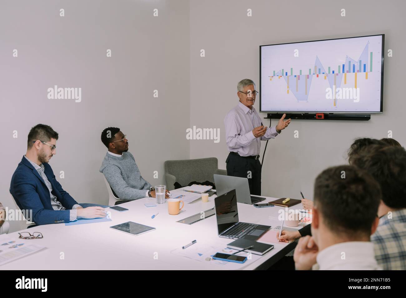 A handsome 70s male business person explaining graph charts on ...