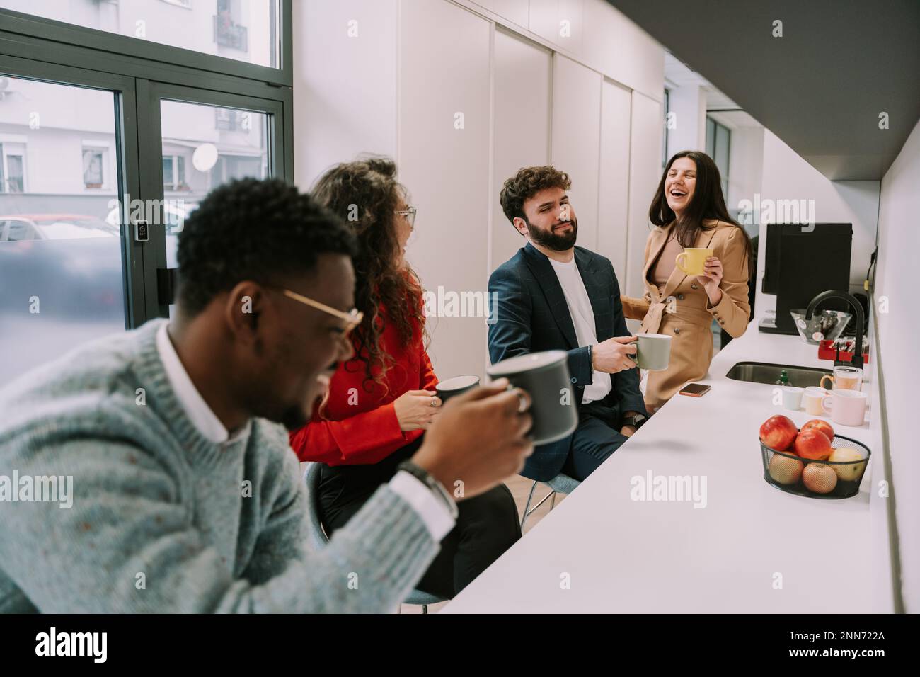 Taking a break from work. Multiracial group of people enjoying coffees ...