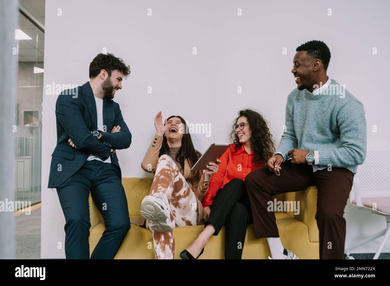 Four attractive business colleagues having fun and laughing while ...