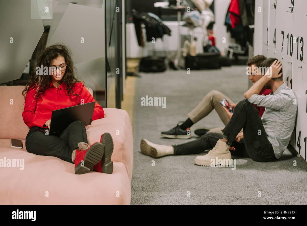 Male coworkers sitting on the floor and having a conversation while ...