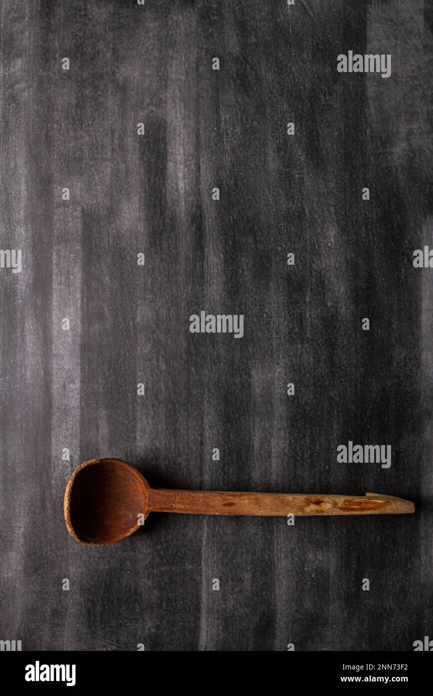 Old big wooden spoon on black background. Flat lay. Top view. Food ...
