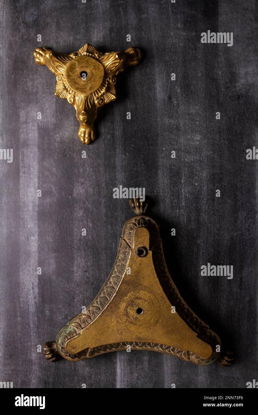 Two antique ornate cast brass electric lamp bases on black background ...