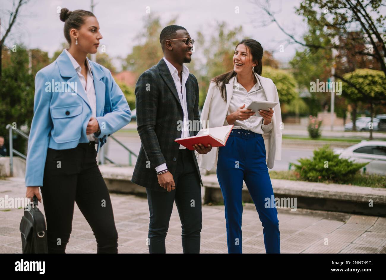 Three business colleagues having a laugh while standing Stock Photo - Alamy