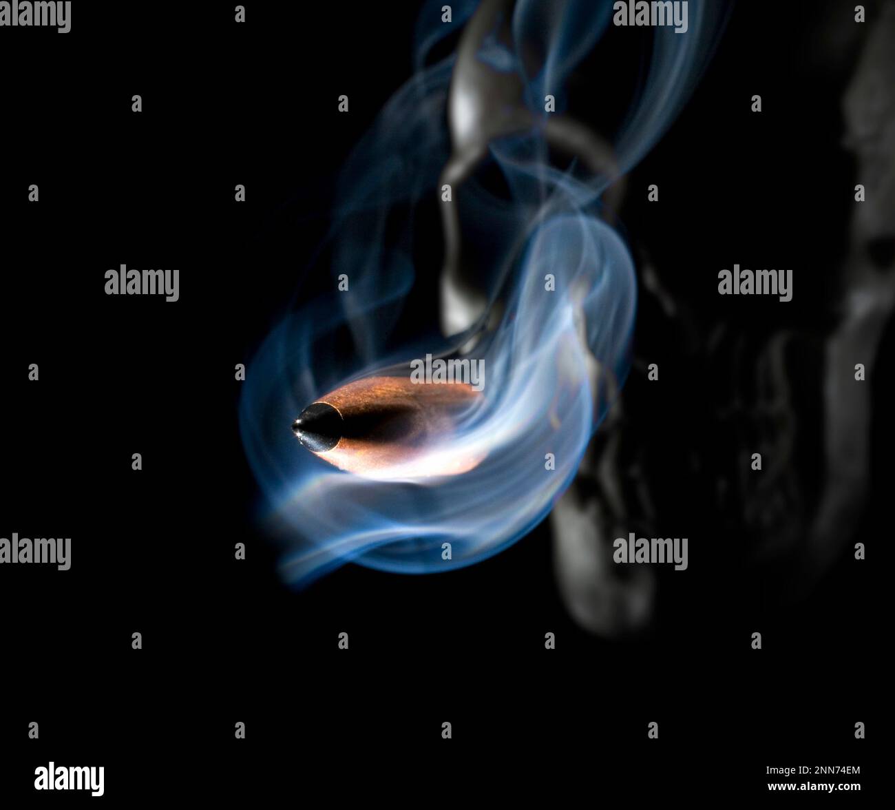 Bullet flying toward the viewer with human skull behind Stock Photo - Alamy