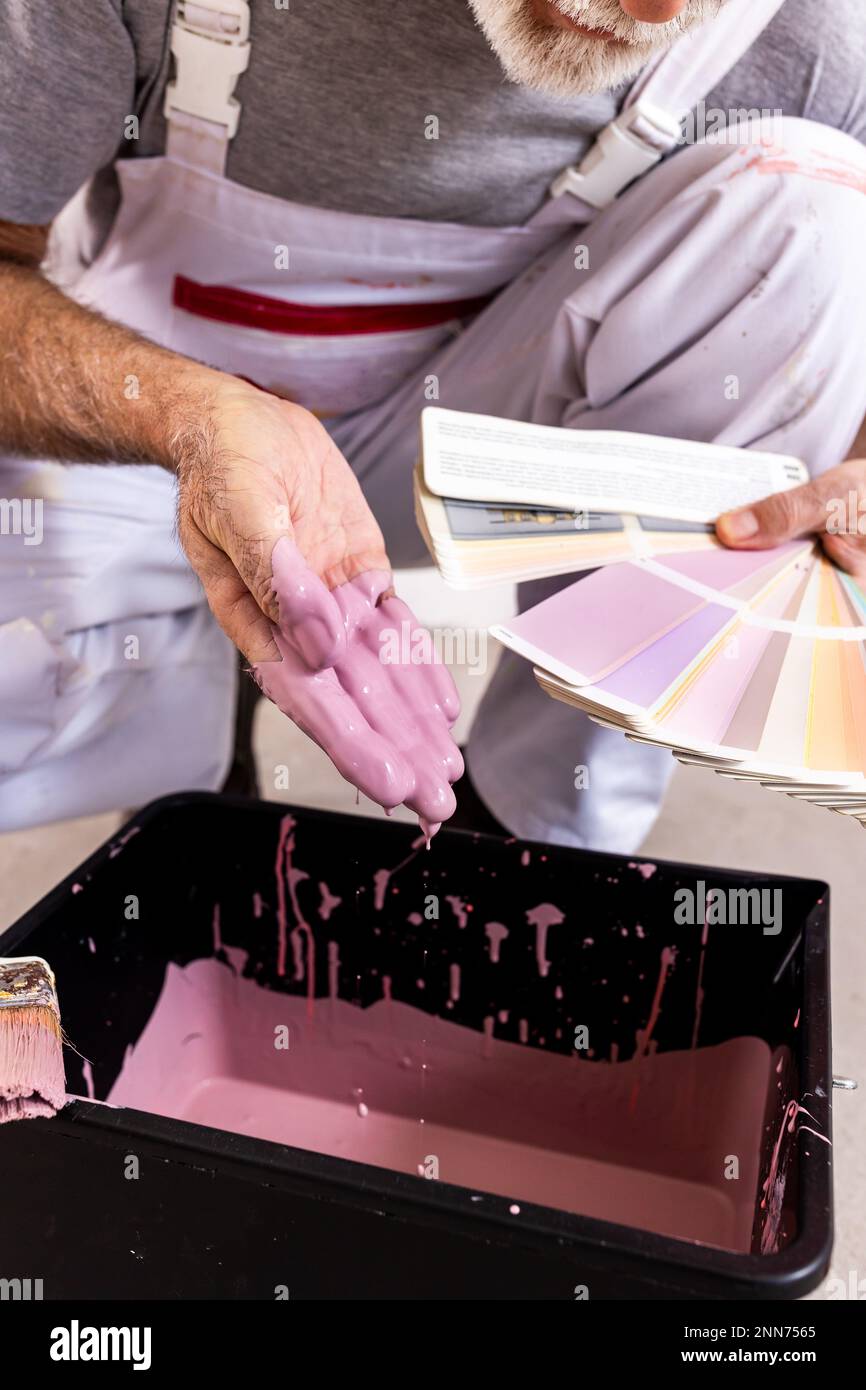 Senior man worker checking paint quality and matching with color ...