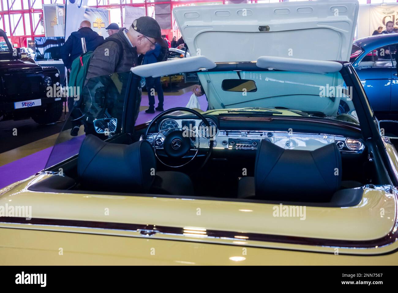 Man looking at the driver seat at ClassicMadrid exhibition of classic ...