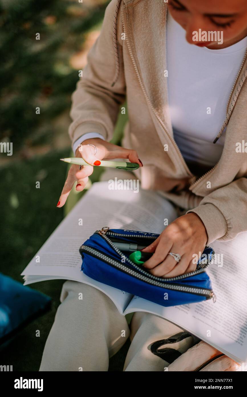 A female high school student took a pen from her pencil case. She is ...