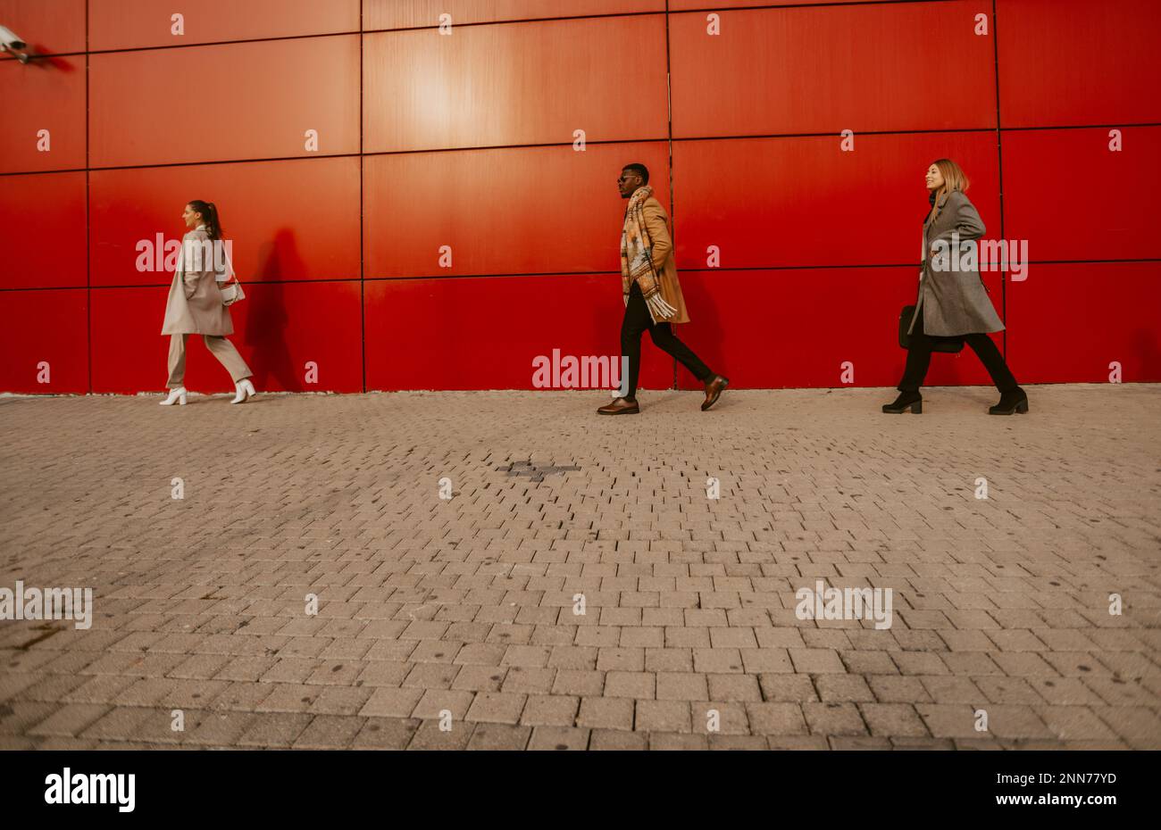 Two businesswomen and one businessman, multiracial colleagues, hanging ...