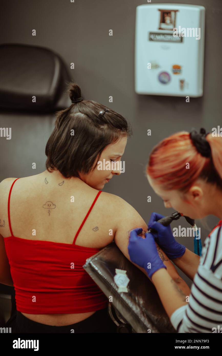 Client is makinf faces while getting tattooed at the studio Stock Photo ...