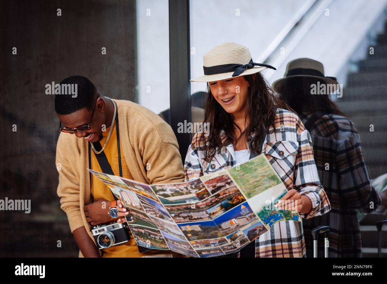 Two multiracial friends are searching for destinations on the map while ...