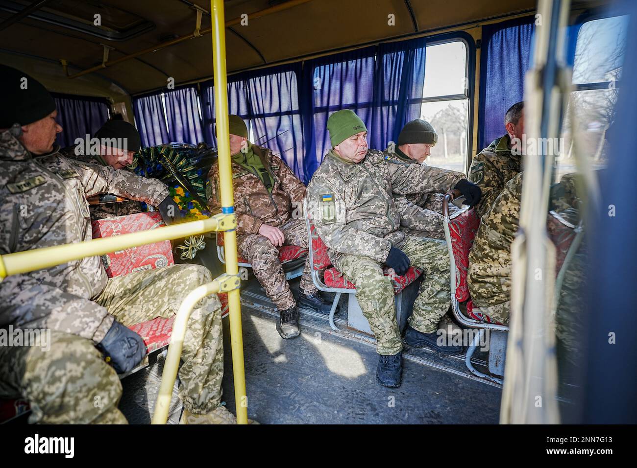 Butscha, Ukraine. 25th Feb, 2023. Comrades sit with the coffin with the ...
