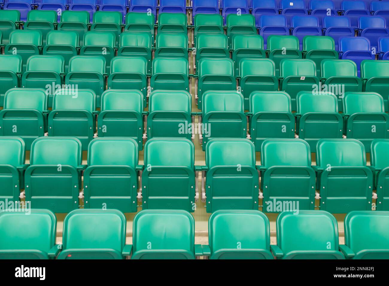Green and blue plastic spectator stadium seats. Nobody, empty rows ...