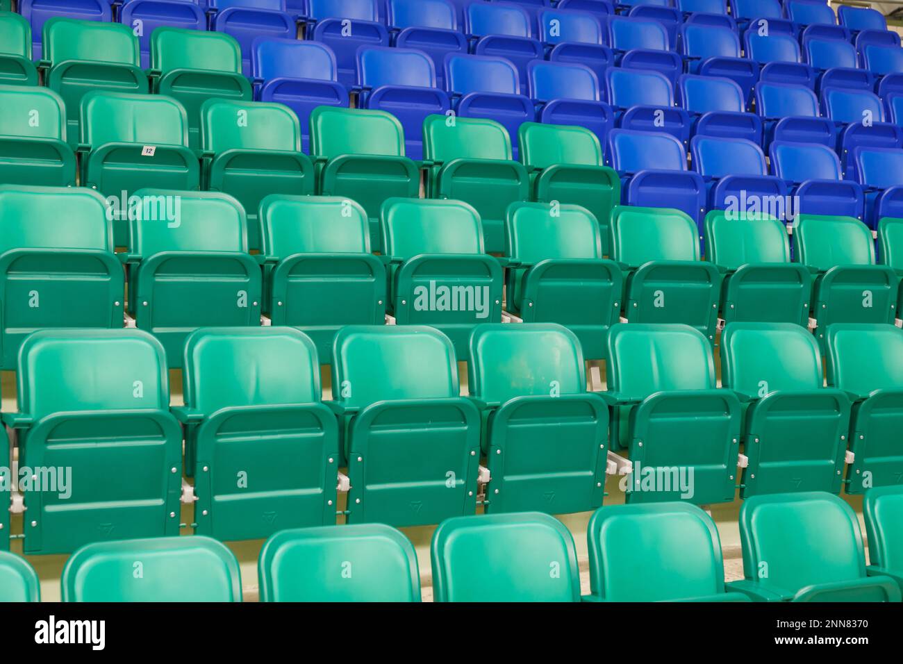 Green and blue plastic spectator stadium seats. Nobody, empty rows ...