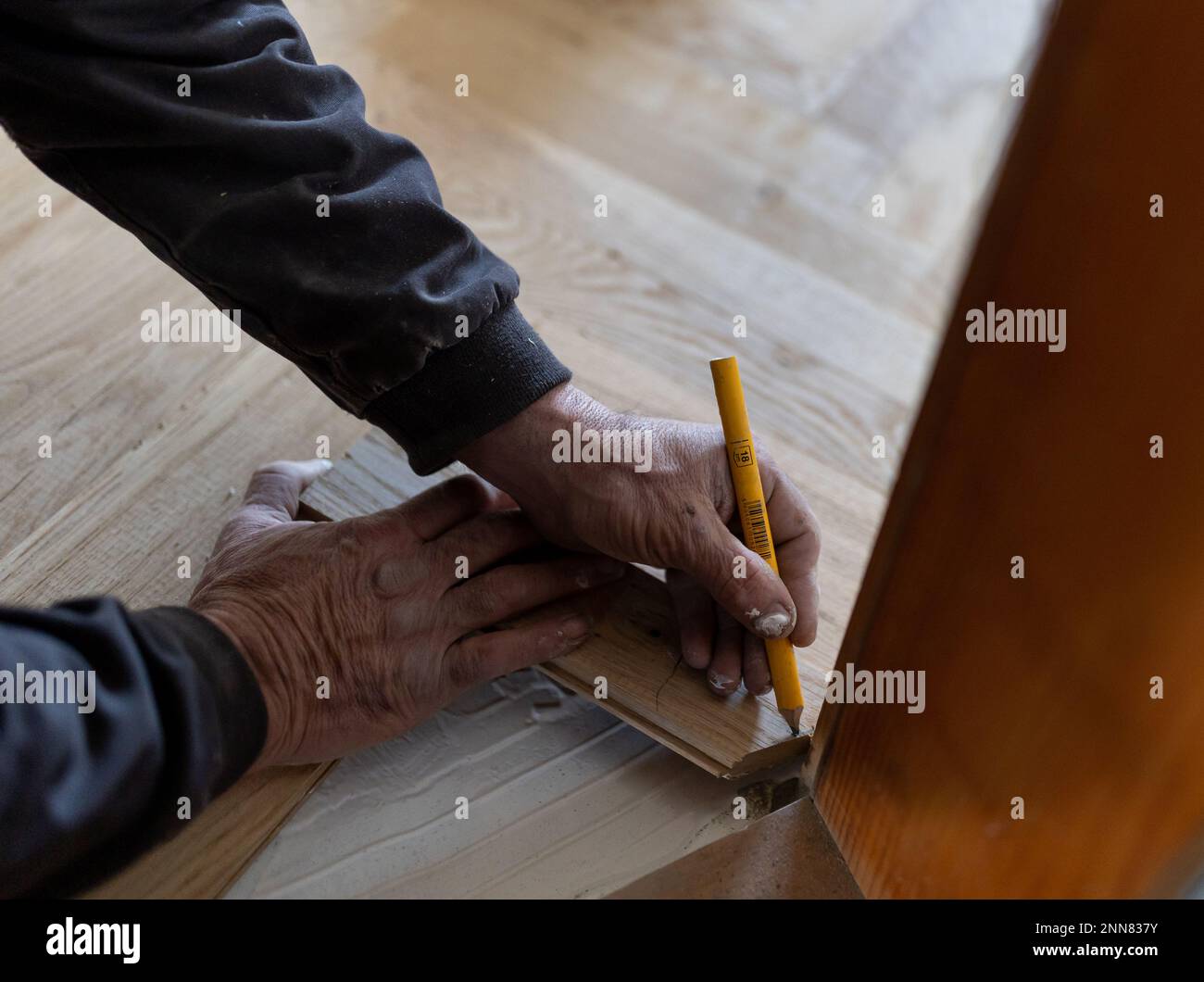Close up of craftsman's work marking parquet for trimming for ...