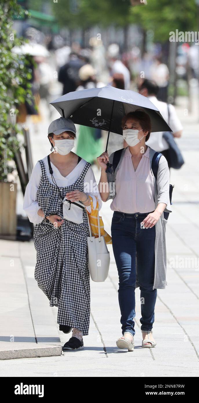 People wearing masks walk in strong sunlight in Ginza district, Tokyo ...