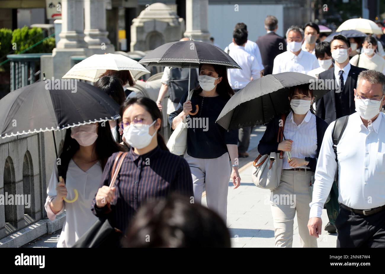 People wearing masks walk in strong sunlight in Osaka City, Osaka ...