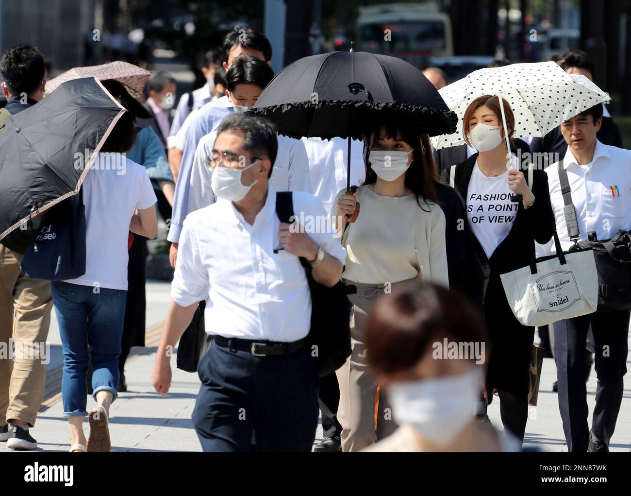 People wearing masks walk in strong sunlight in Osaka City, Osaka ...