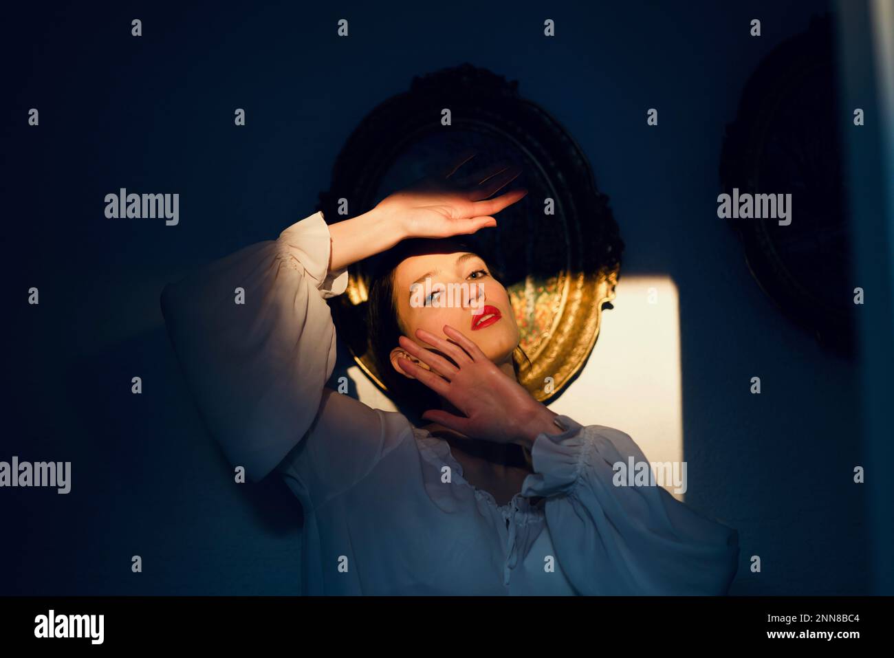 Woman in Shadow with Hands around Face Stock Photo - Alamy