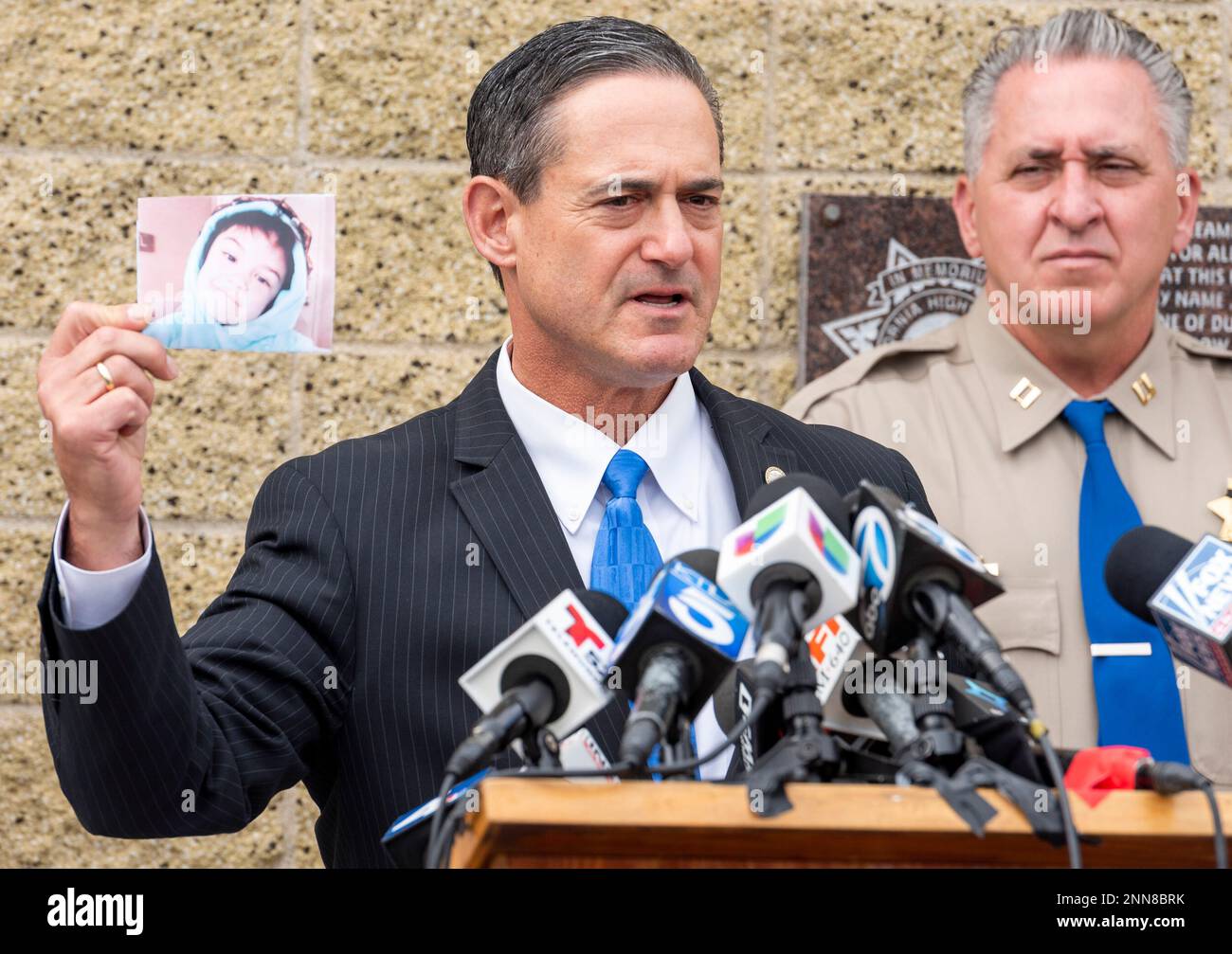 Orange County District Attorney Todd Spitzer holds up a photo of Aiden ...