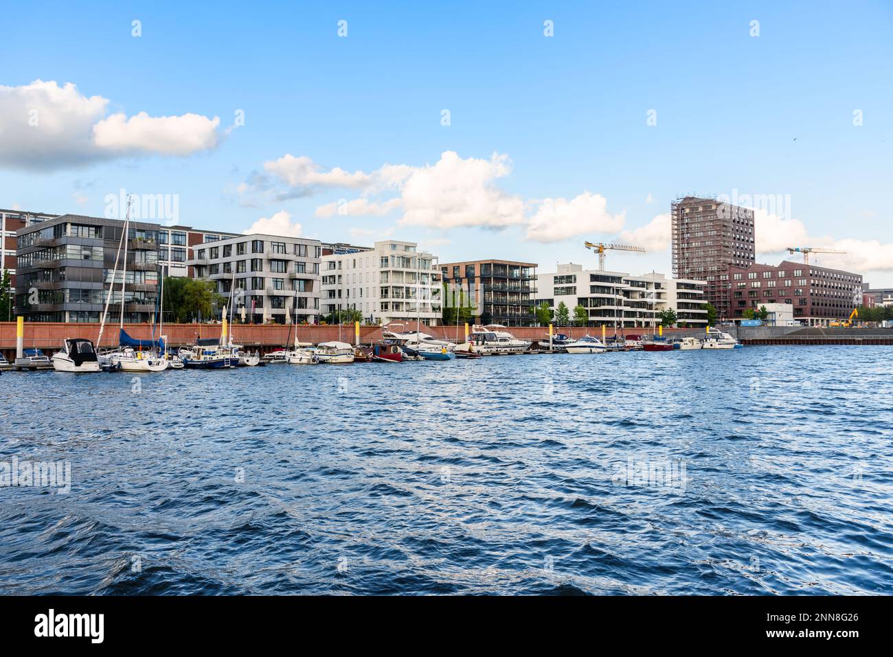 Modern waterfront apartment buildings along a harbour on a clear summer ...