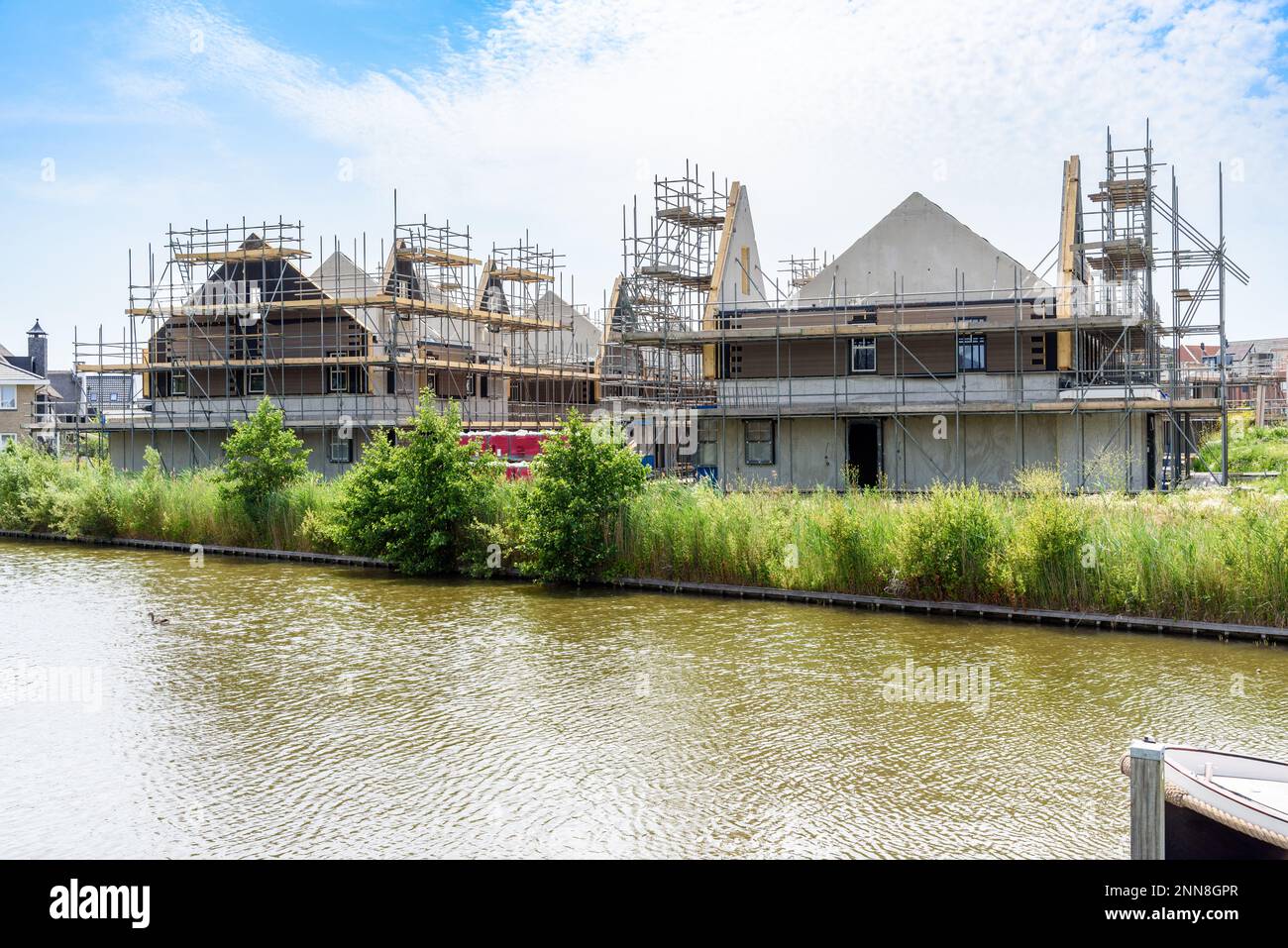 Houses in construction in a housing development along a canal in the ...