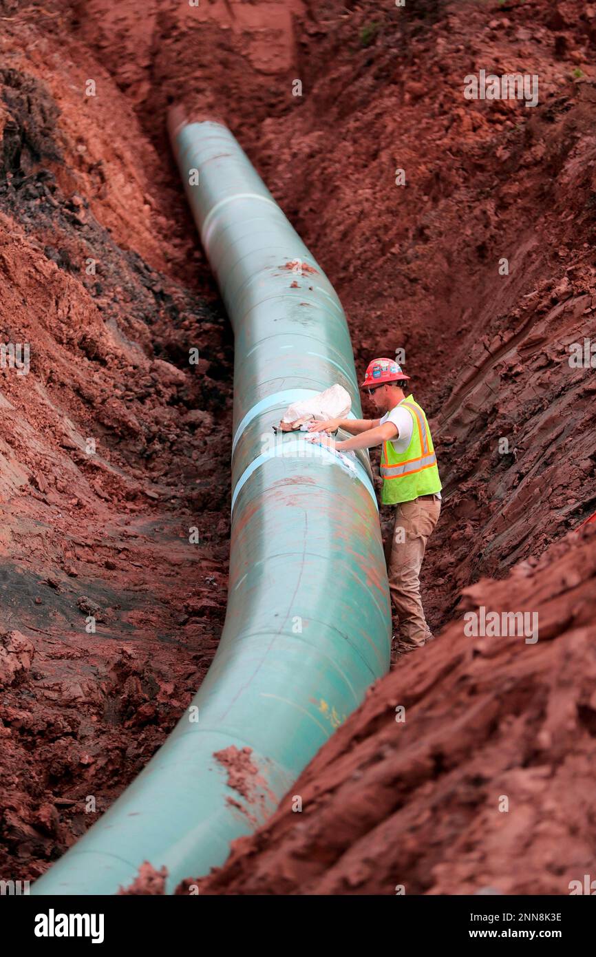 FILE - In this Aug. 21, 2017, file photo, a pipe fitter lays the ...