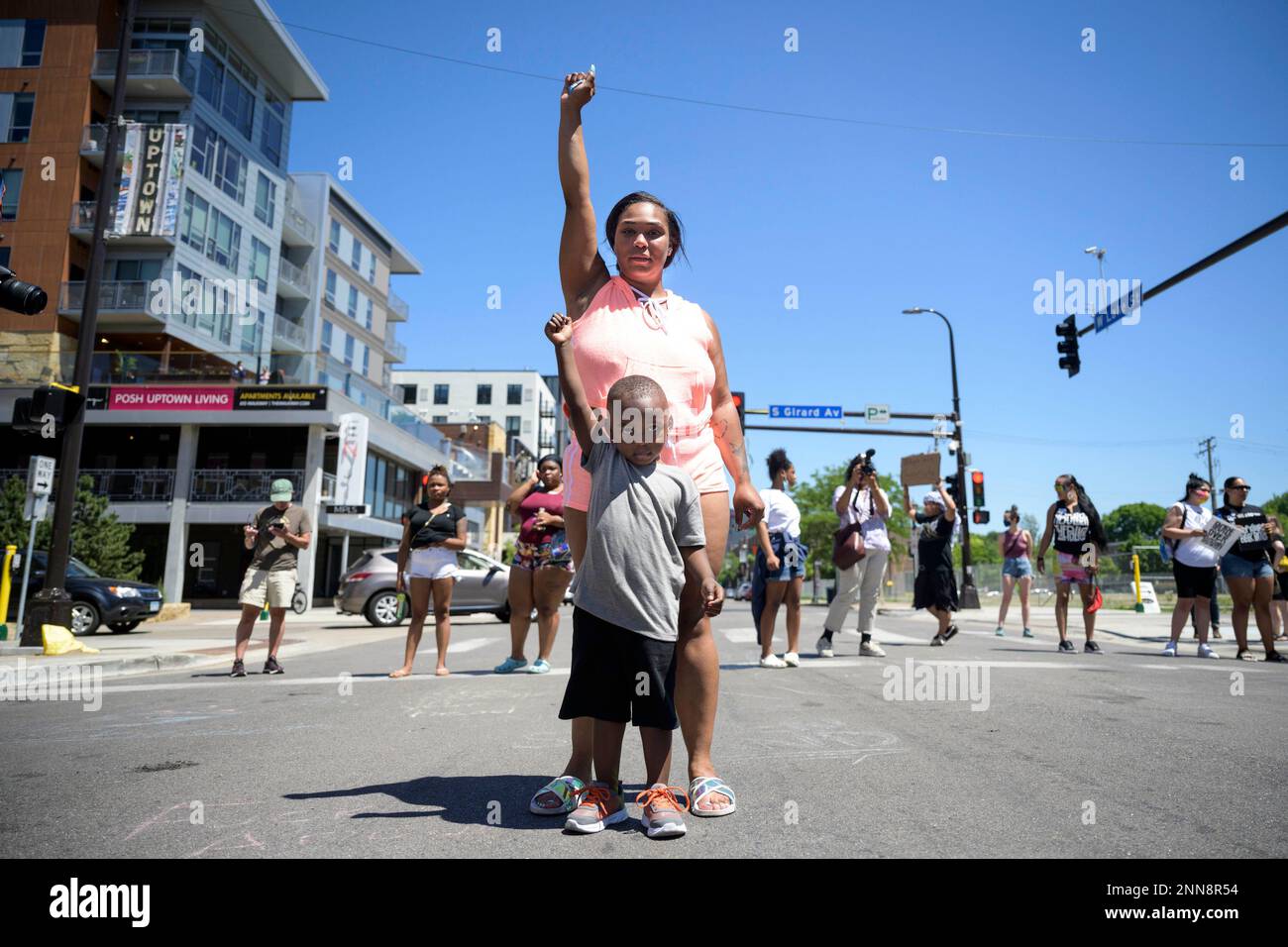 Starr Patterson stands with a child as they raised their fist in the ...