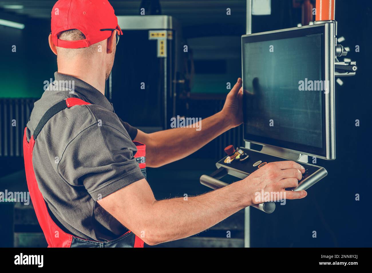 Industrial Machinist Operating the Laser Cutter Machine Console ...