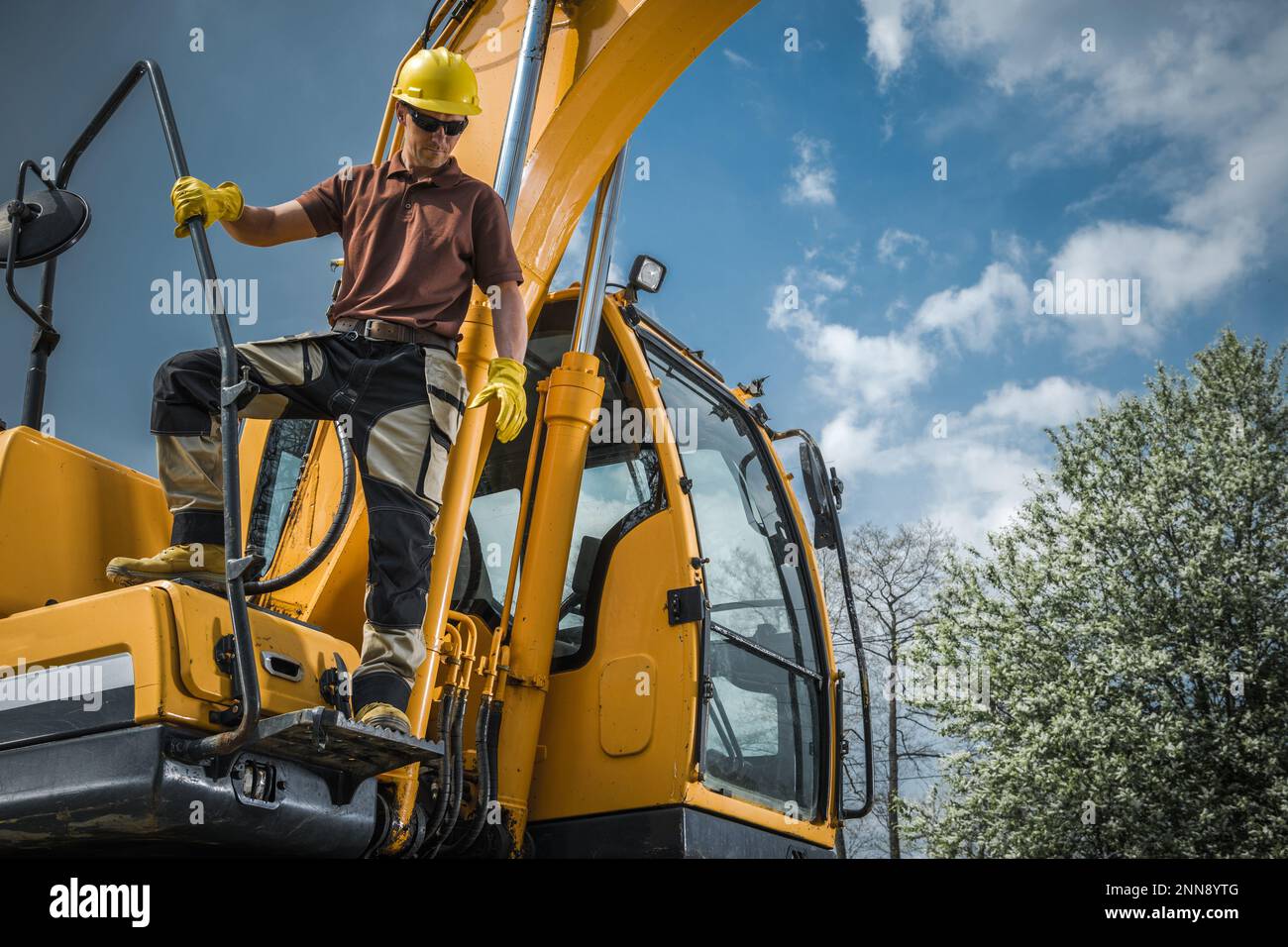 Professional Heavy Duty Machinery Operator Standing on Excavator Machine. Construction Industry ...