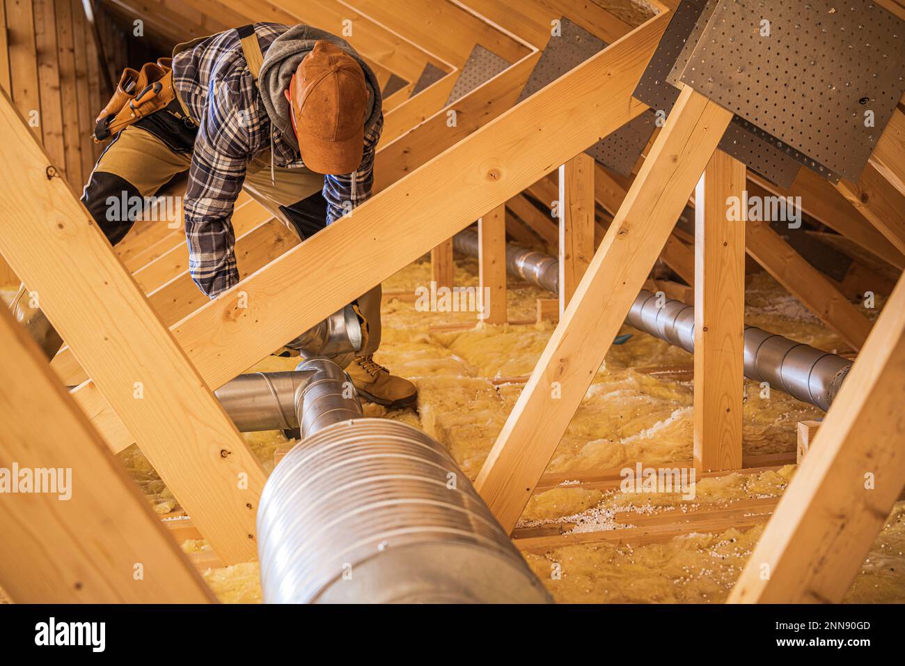 Professional HVAC Technician Installing Air Ducts in the Wooden Roof ...
