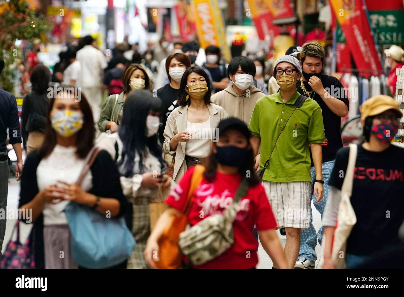 People wearing face masks walk in a shopping district in Nagoya ...