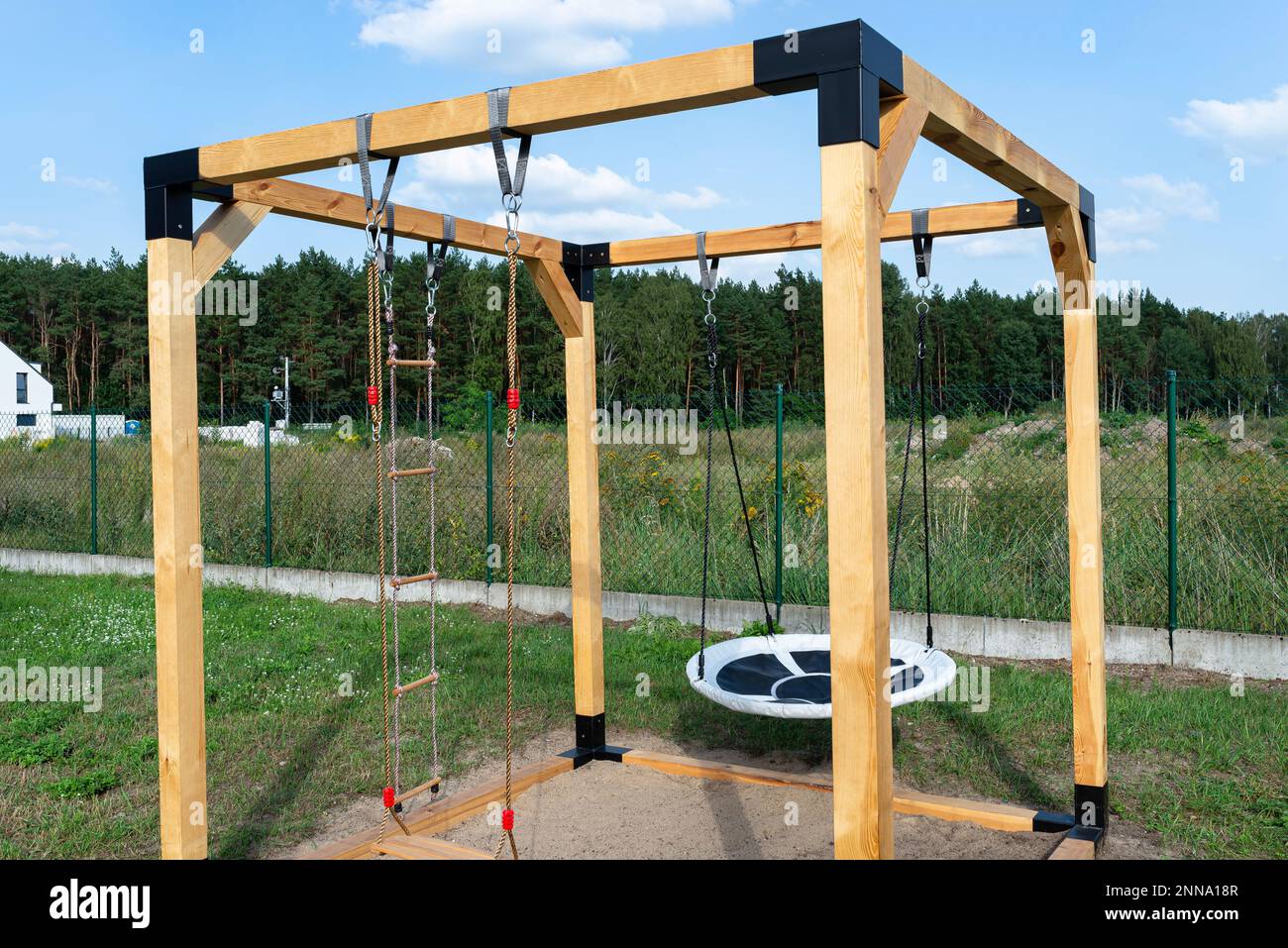 A modern cube playground made of wood and metal corners, standing in ...