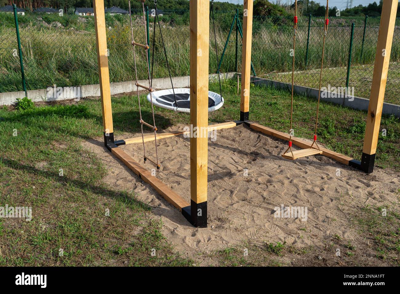 A modern cube playground made of wood and metal corners, standing in ...