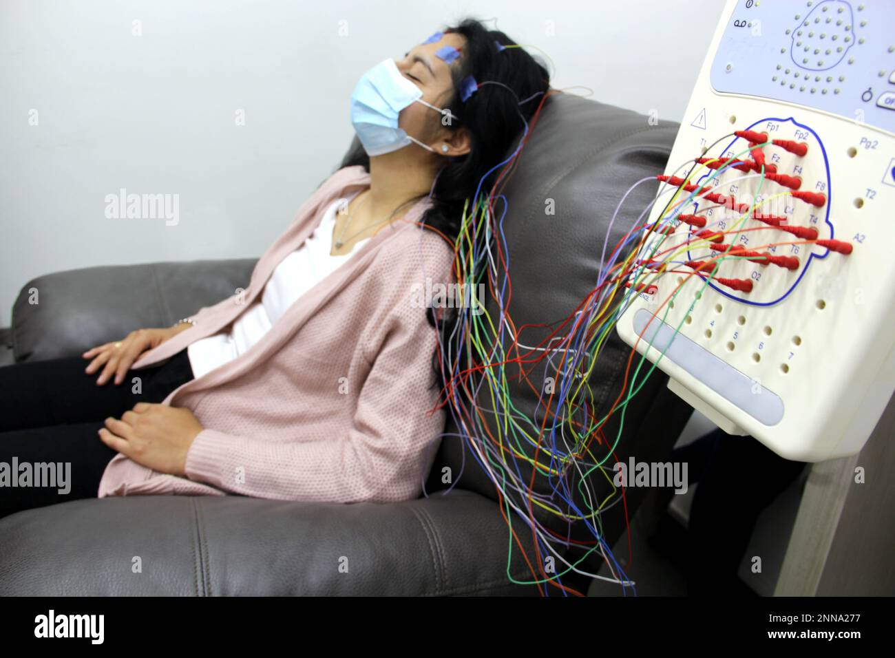 Latin woman with protection mask in medical tests, electroencephalogram ...